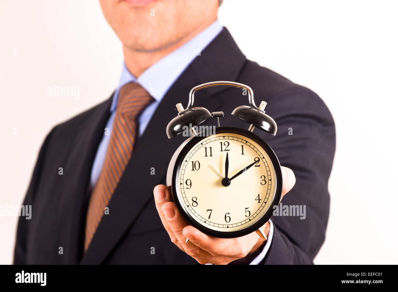 Businessman holding clock Stock Photo - Alamy