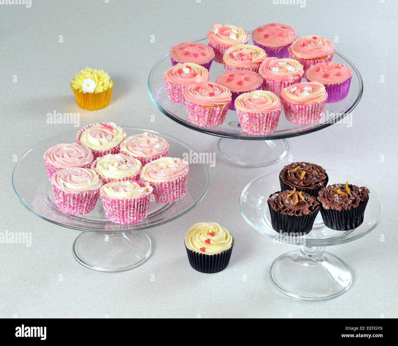 A selection of cup cakes on glass platters Stock Photo - Alamy
