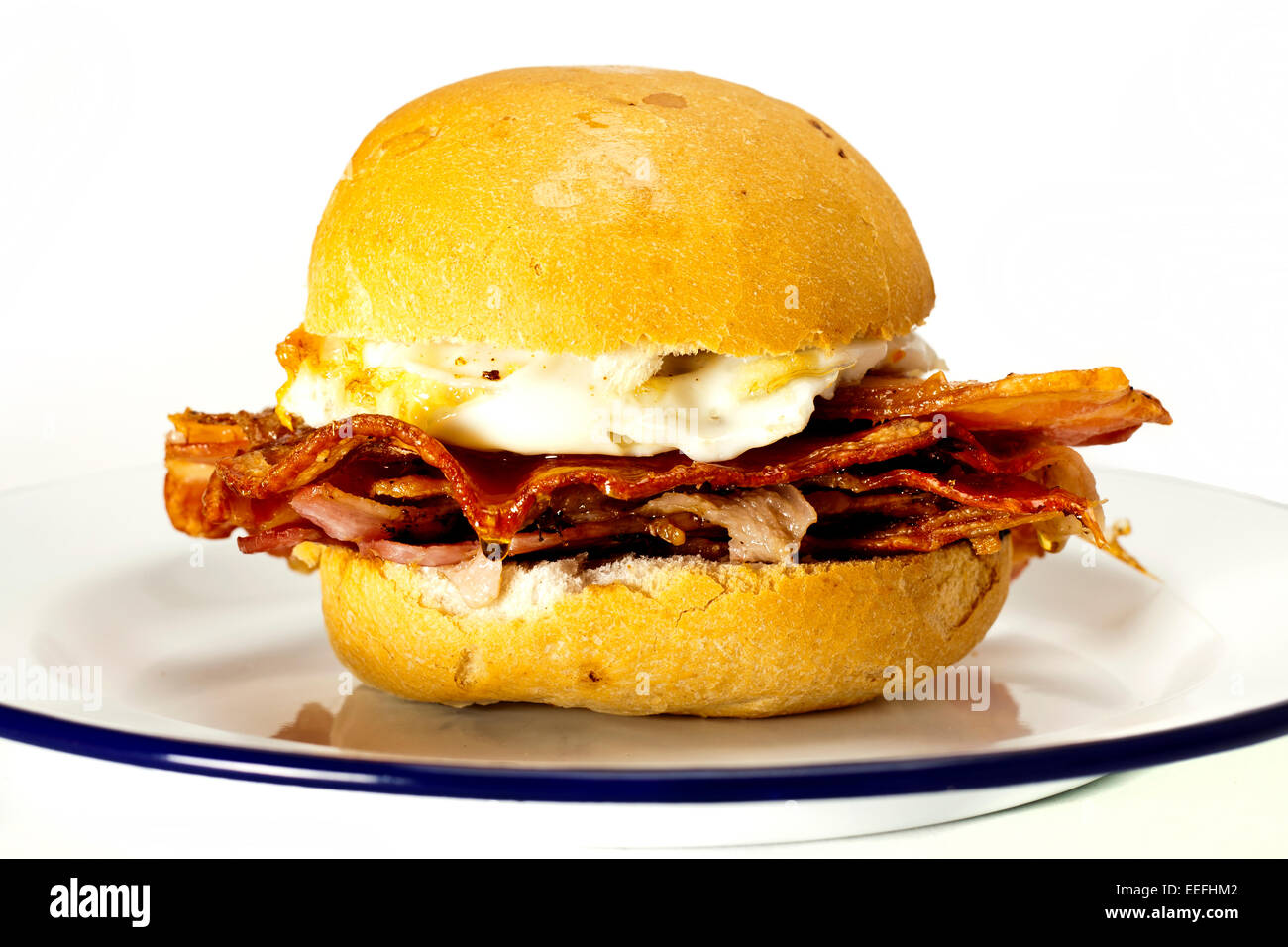 A delicious bacon and egg bun on a white background Stock Photo - Alamy