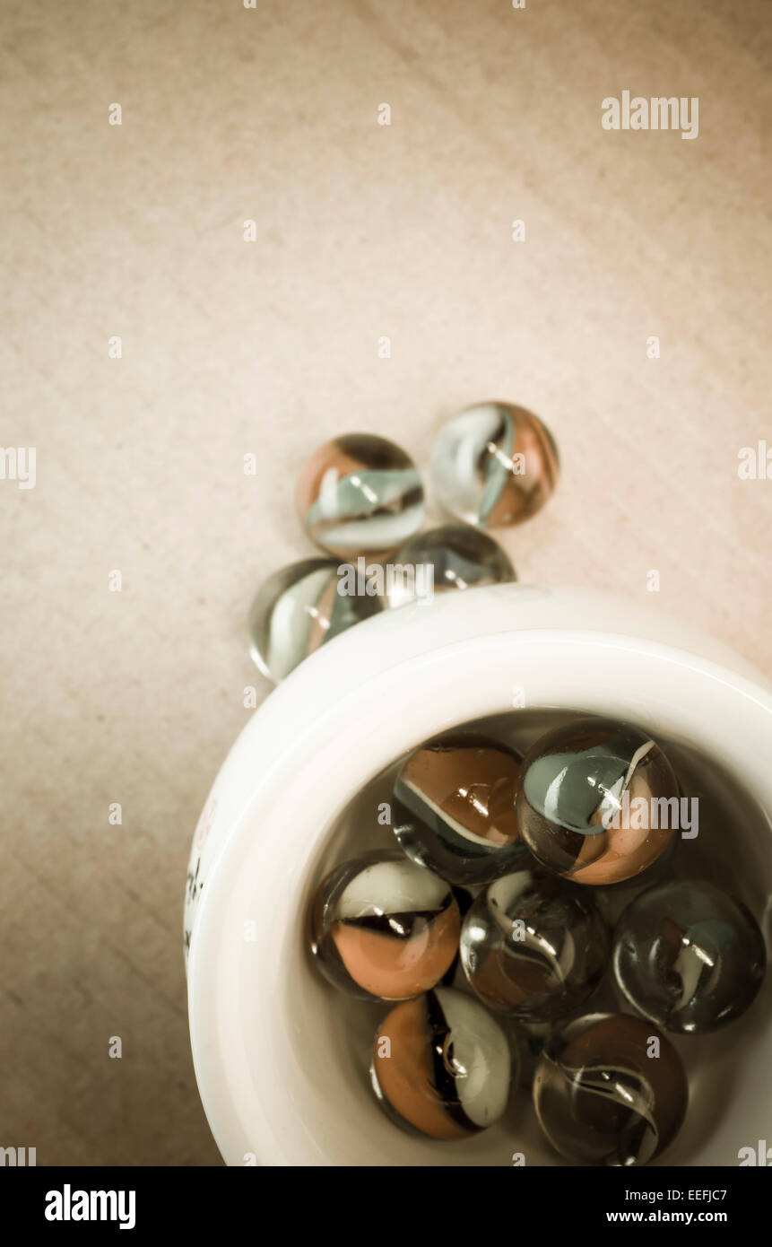 many glass balls in a white porcelain container Stock Photo - Alamy