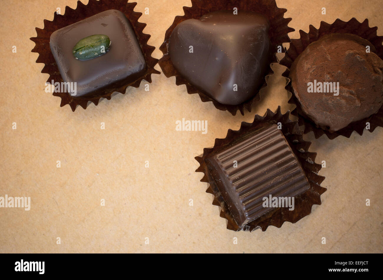 four fine sweet chocolate on a light brown surface Stock Photo - Alamy