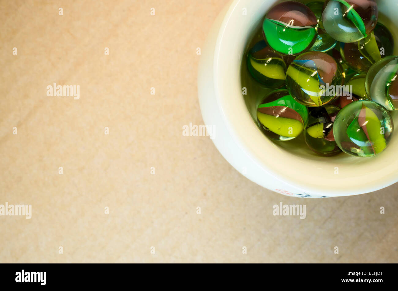 glass balls in a white porcelain container, paperboard background Stock ...