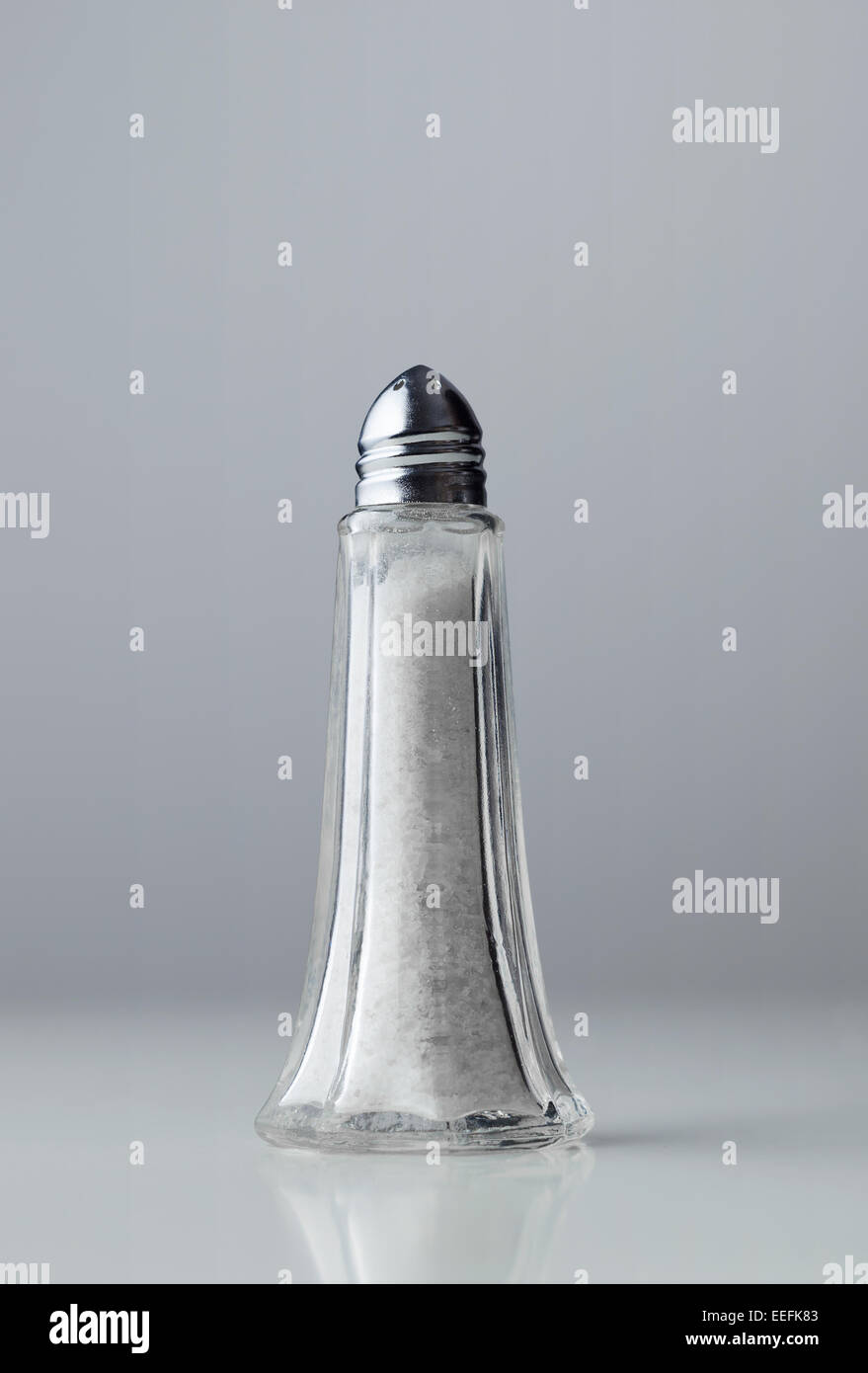 Close up of a salt shaker over bluish background Stock Photo - Alamy