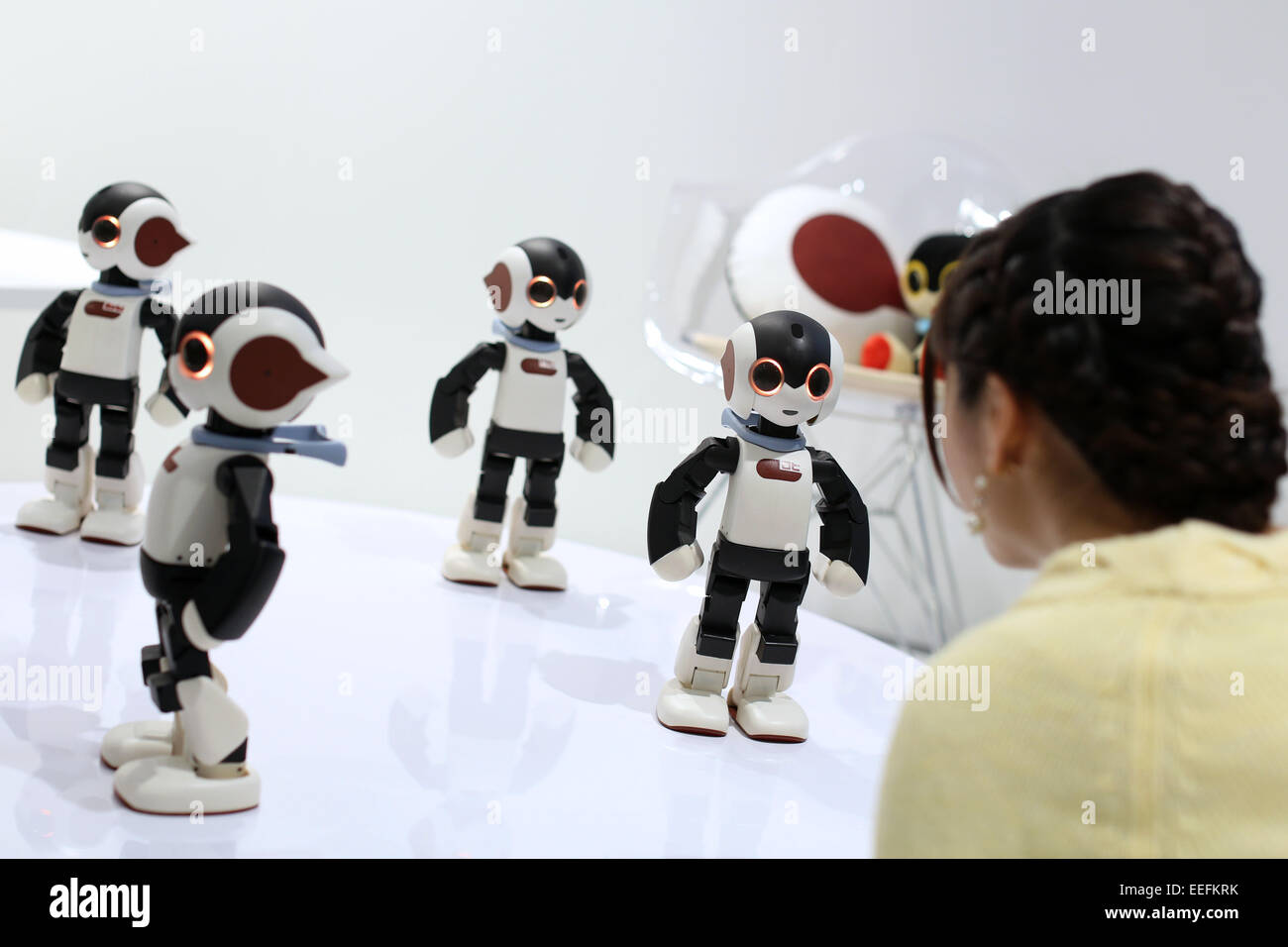 Tokyo, Thursday. 15th Jan, 2015. A woman speaks to communication robots ...