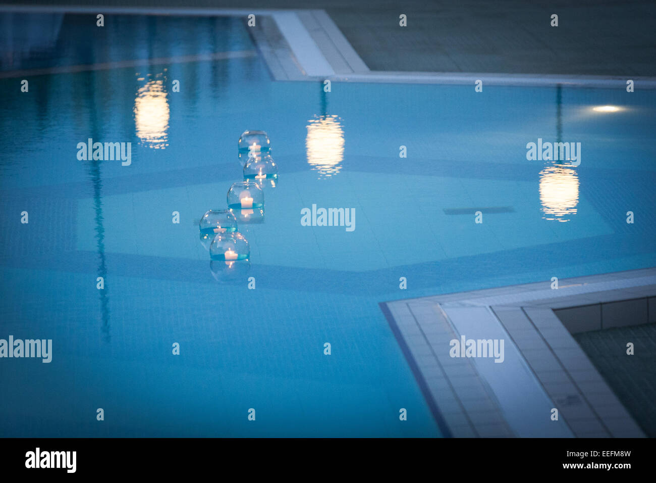Candles in glass bowls floating in swimming pool Stock Photo - Alamy
