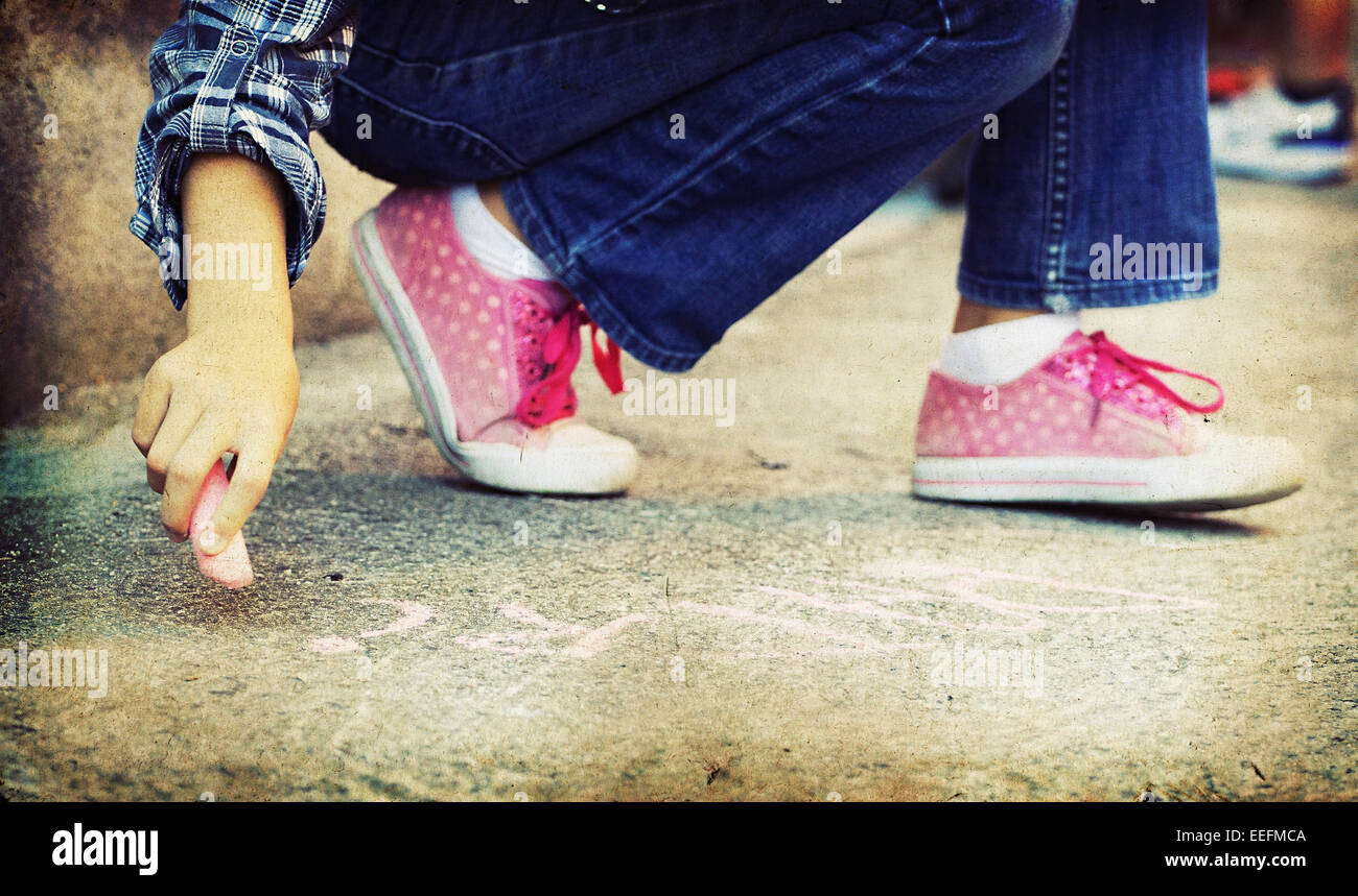 Vintage photo of little girl in jeans writing with chalk on the ...