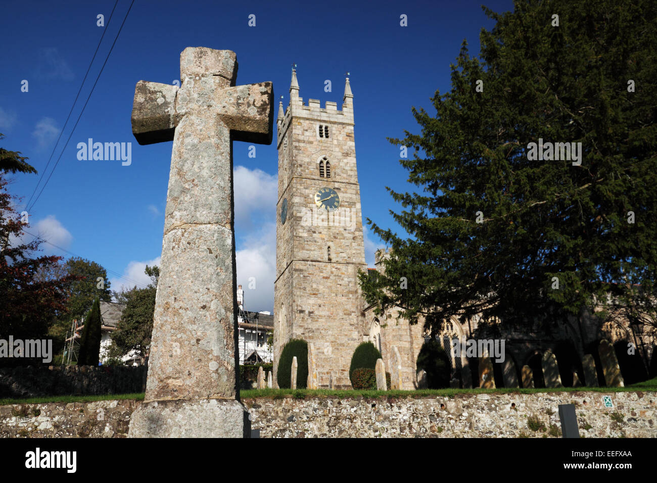 A large granite cross in front of a tall church tower Stock Photo - Alamy