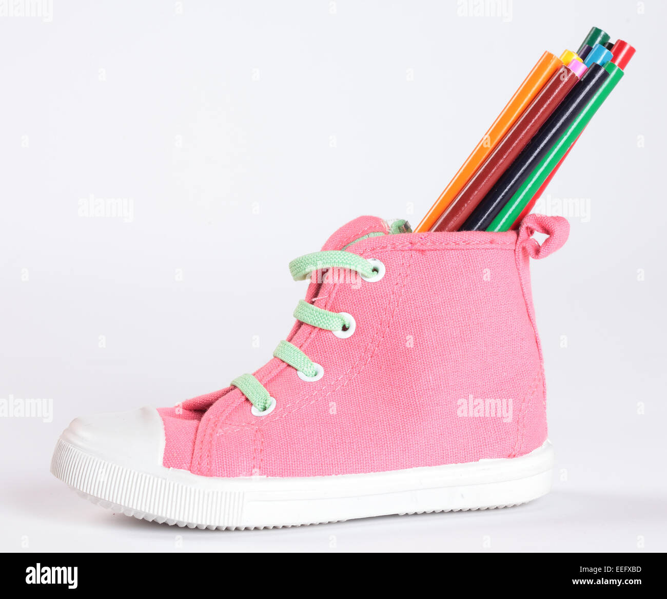 child shoe with colored pencils on a white background Stock Photo - Alamy