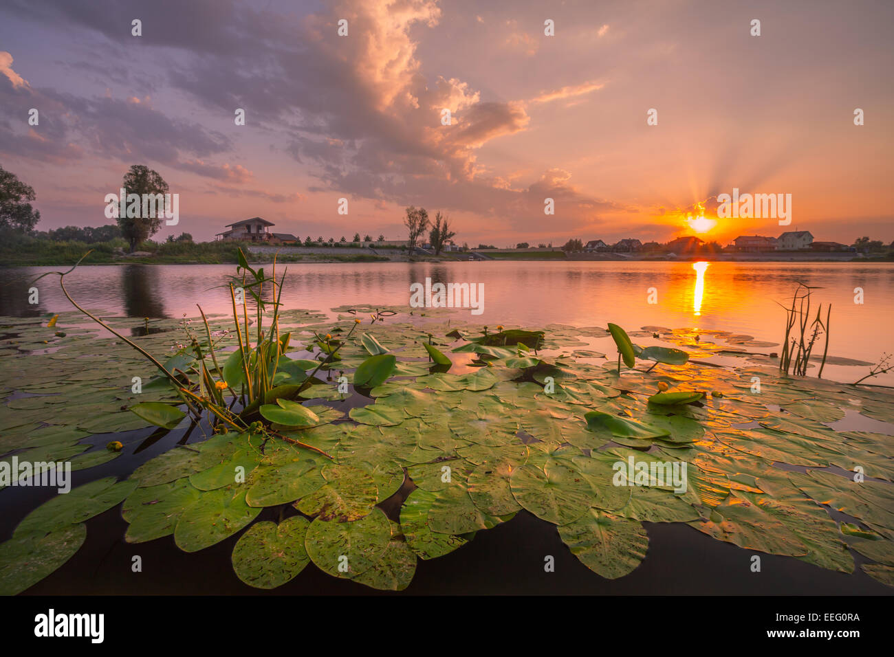 Amazingly colorful sunset with reflective red sand and bright clouds ...
