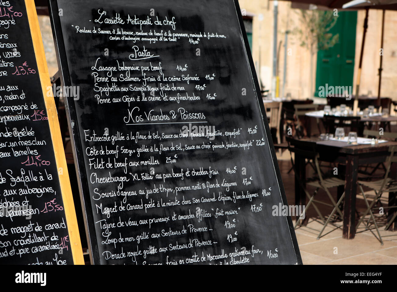 Paris, France restaurant menu board with tables and chairs in the ...