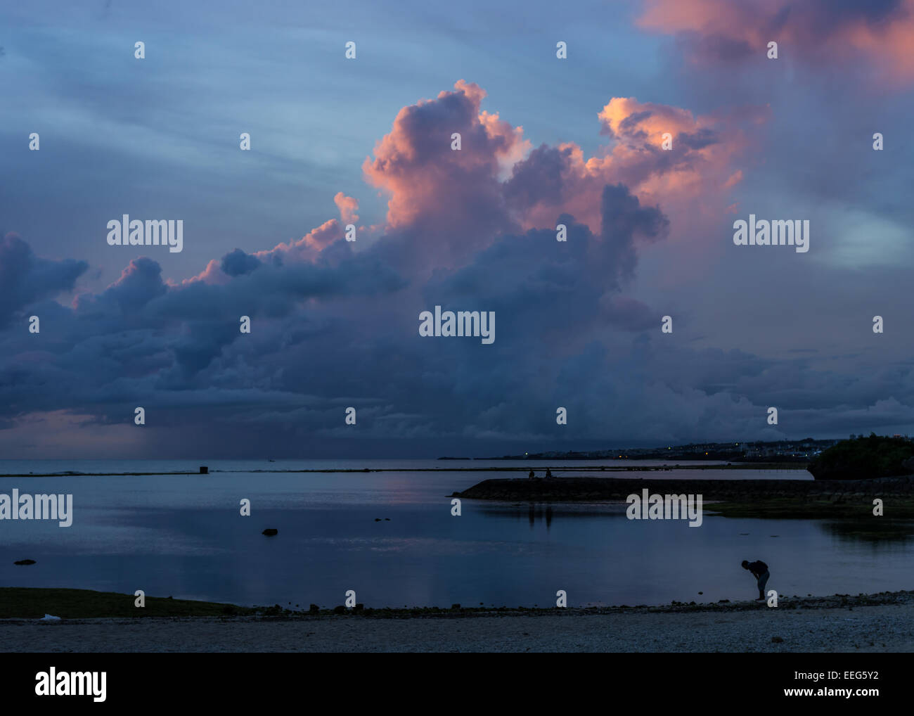 Fishermen pause to watch the sunset at Sunabe Beach in Okinawa, Japan ...