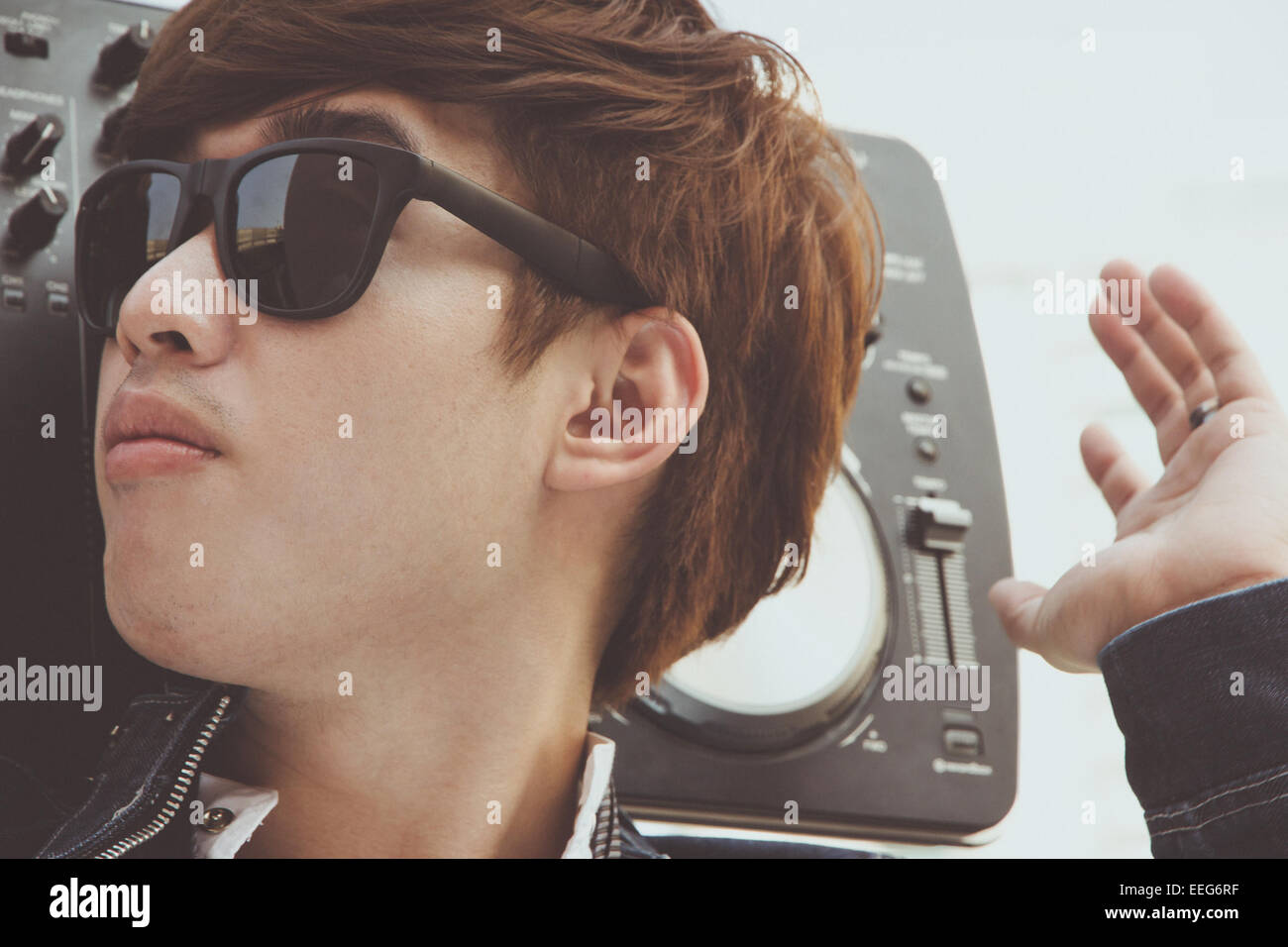 Handsome asian guy with turntables dj mixer Stock Photo - Alamy