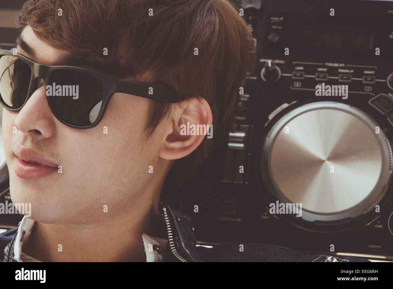 Handsome asian guy with turntables dj mixer Stock Photo - Alamy