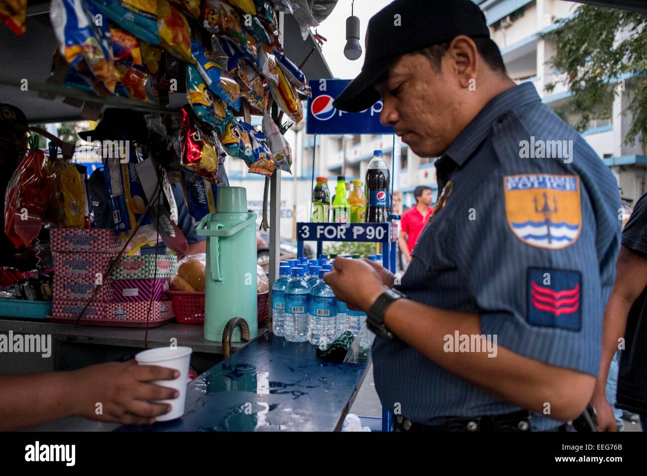 Manila, Philippines, 16th Jan, 2015. A police officer takes his coffee ...