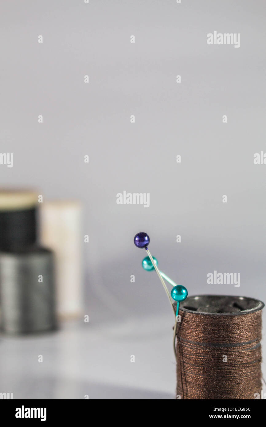 Needle embroidery thread rolling brown Stock Photo - Alamy