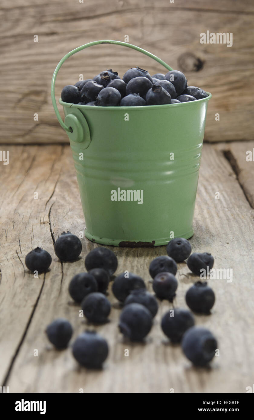 blueberries in a green bucket on rustic wood Stock Photo - Alamy