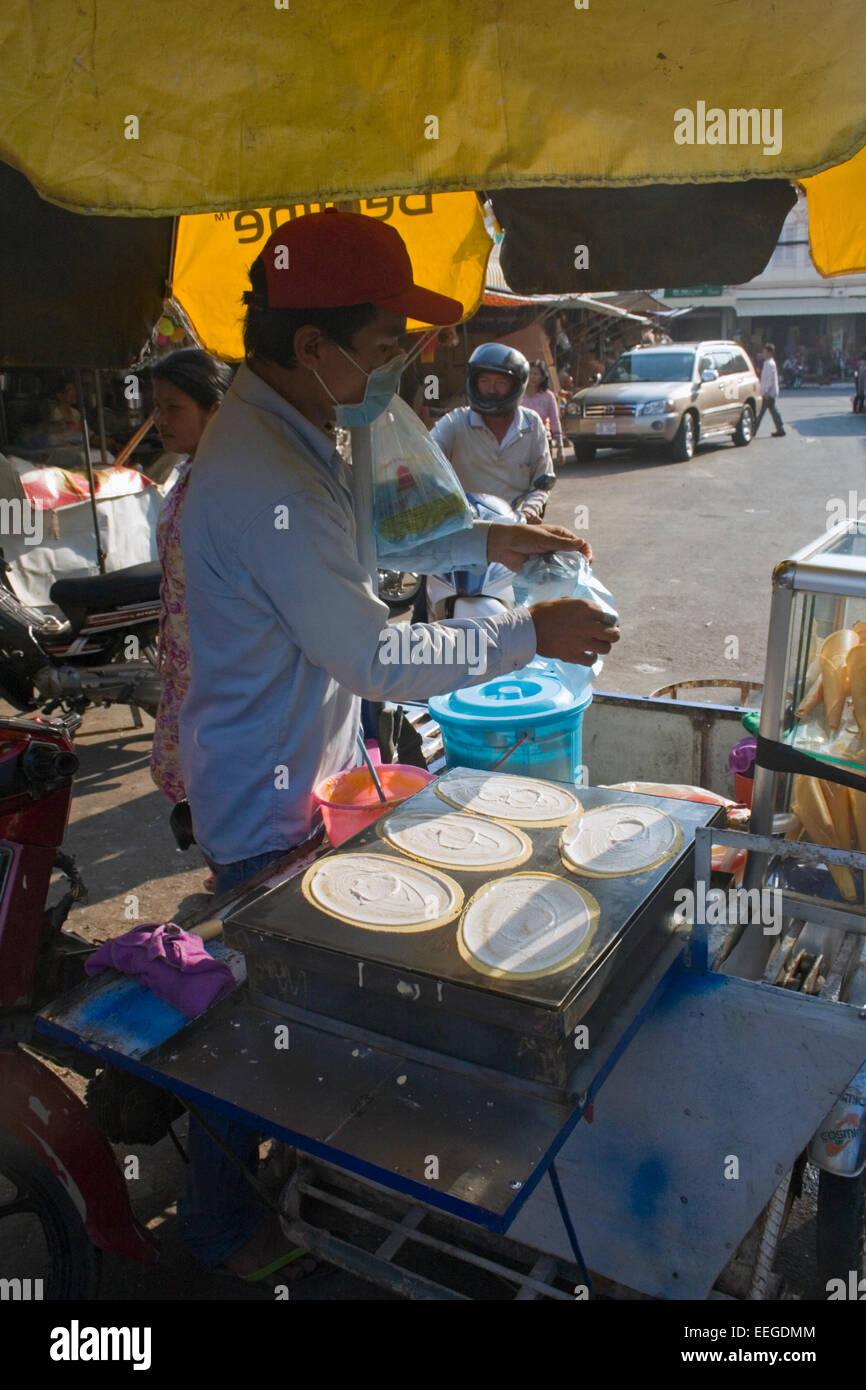 A man is making roti, a popular street food in southeast Asia, on a ...
