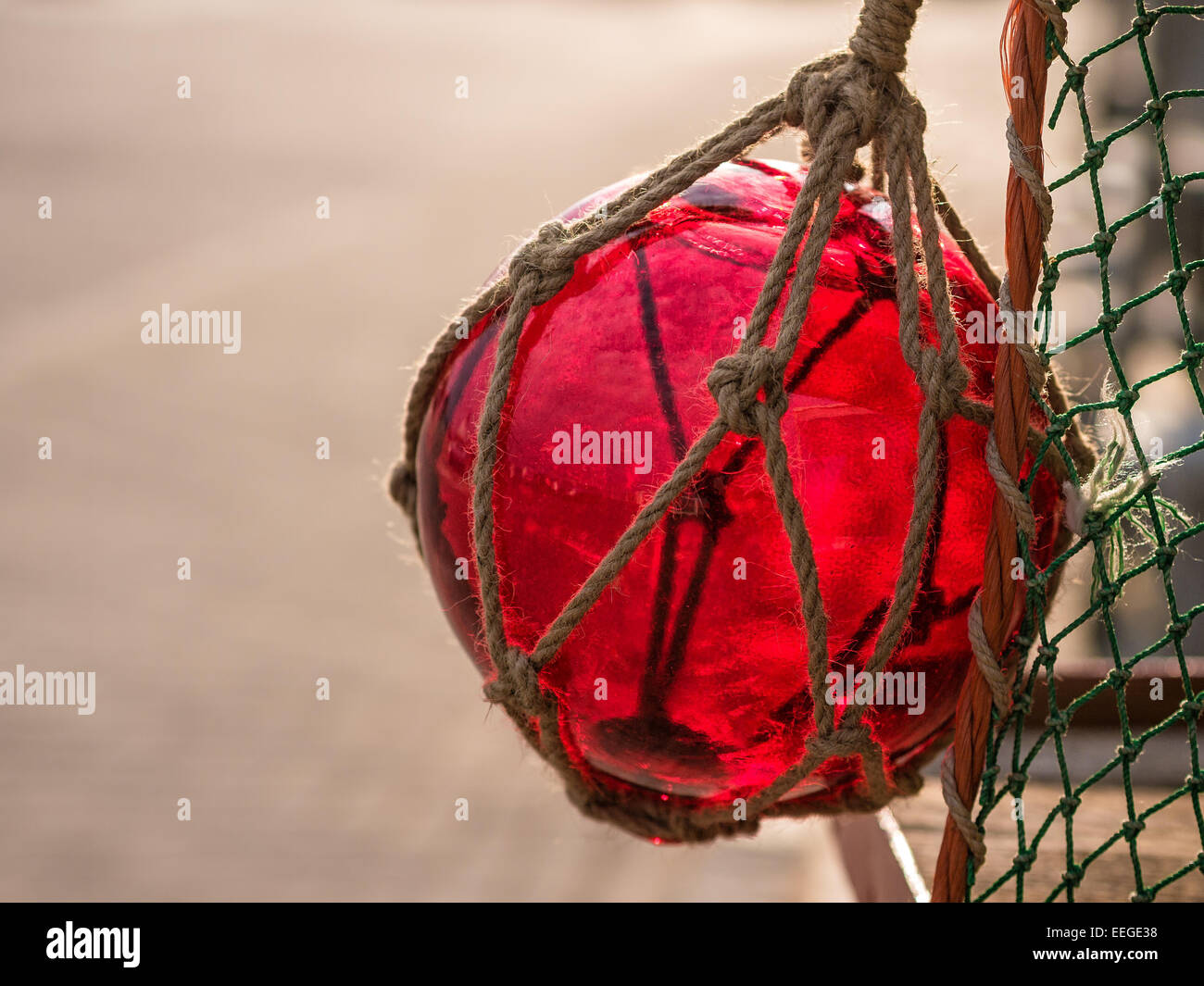 A red ball of glass with rope Stock Photo - Alamy
