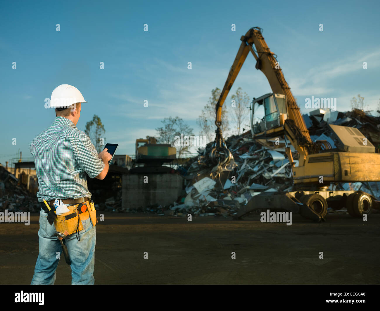 back view of engineer wearing protective equipment, holding digital ...