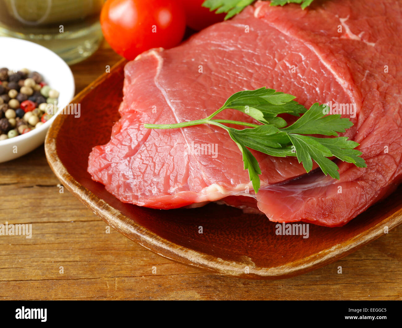 fresh raw beef meat with pepper and herbs on wooden plate Stock Photo ...