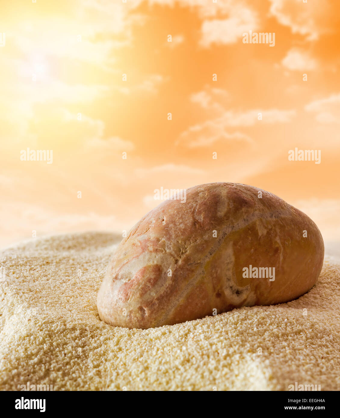 stone pebble on the sand and with tropical background Stock Photo - Alamy