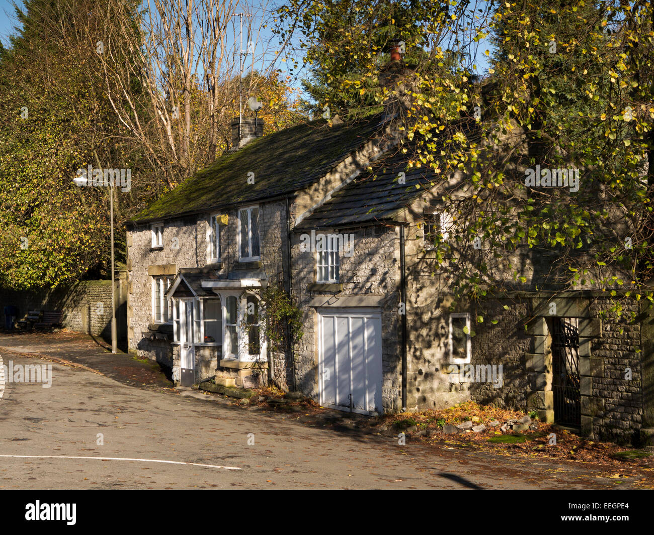 UK, Derbyshire, Tideswell, High Street, Vicarage Cottage in dappled ...