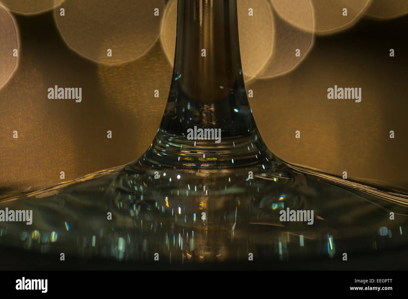 Macro photograph of the stem and base of a wine glass with lights ...