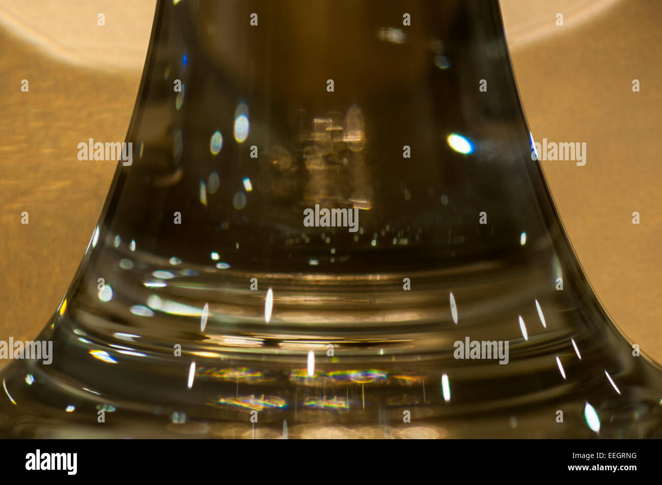 Macro photograph of the stem and base of a wine glass with lights ...