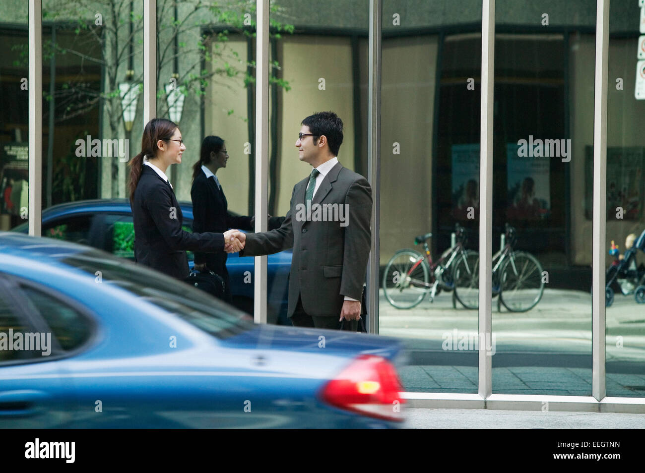 Business couple shaking hands outside Stock Photo - Alamy
