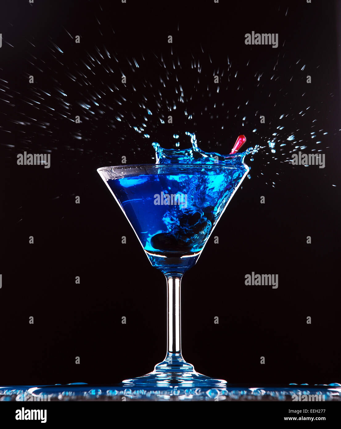 blue cocktail splashing on dark background Stock Photo - Alamy
