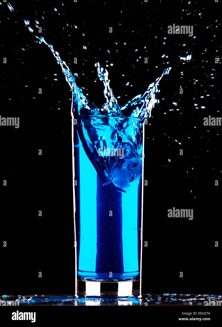 blue cocktail splashing on dark background Stock Photo - Alamy