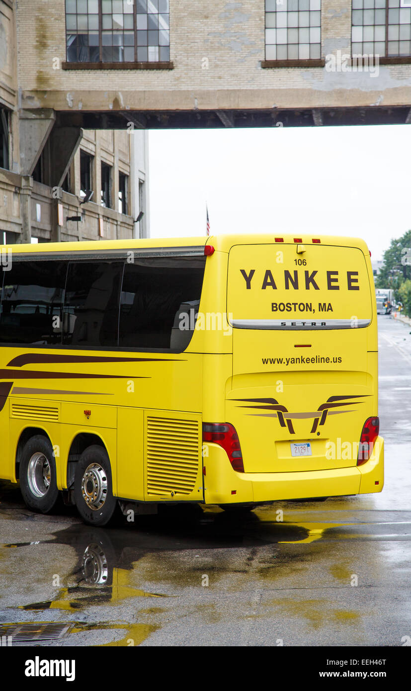 A bright yellow Yankee tour bus in a parking lot in Boston ...