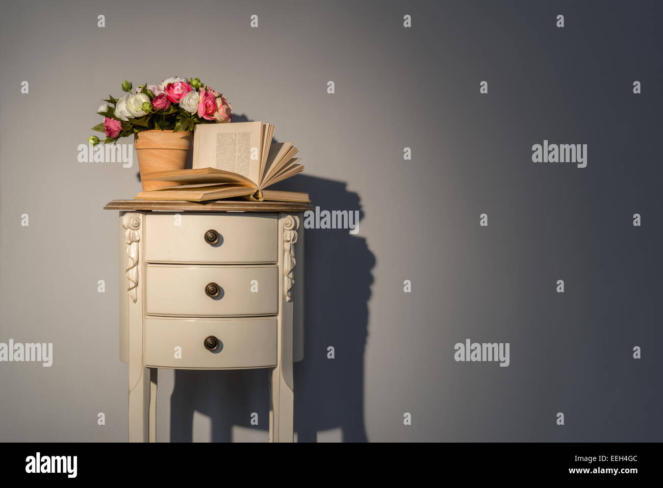 Couch table with flowers and book Stock Photo - Alamy
