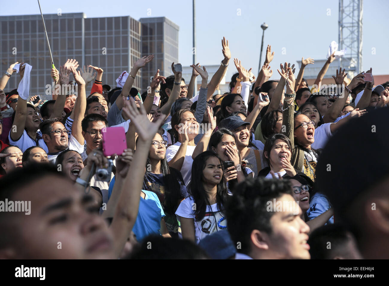 Manila, Philippines. 19th Jan, 2015. Crowd raise their arms to the Pope ...