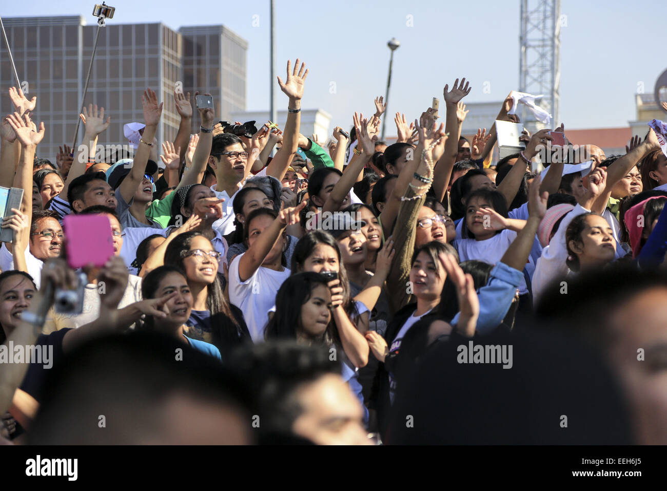 Manila, Philippines. 19th Jan, 2015. Crowd raise their arms to the Pope ...