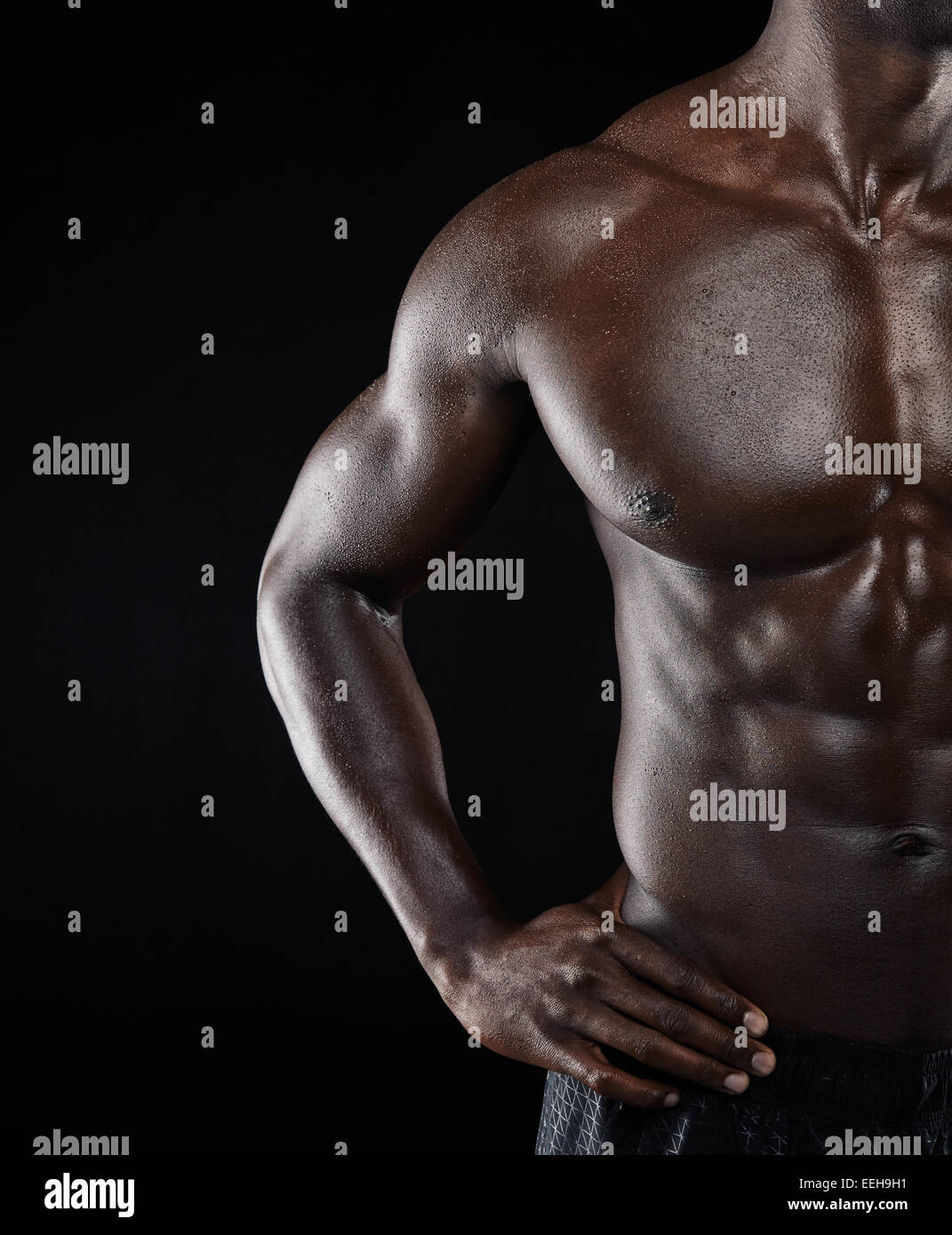 Close-up shot of young African muscular man body against black ...