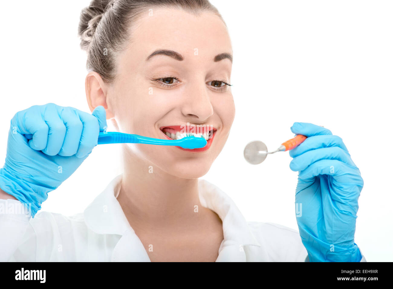 Young smiling woman doctor in uniform brushing teeth on white ...