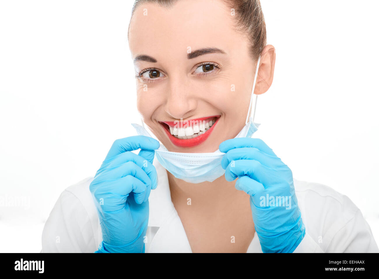 Young woman doctor taking off operation mask smiling and looking at ...