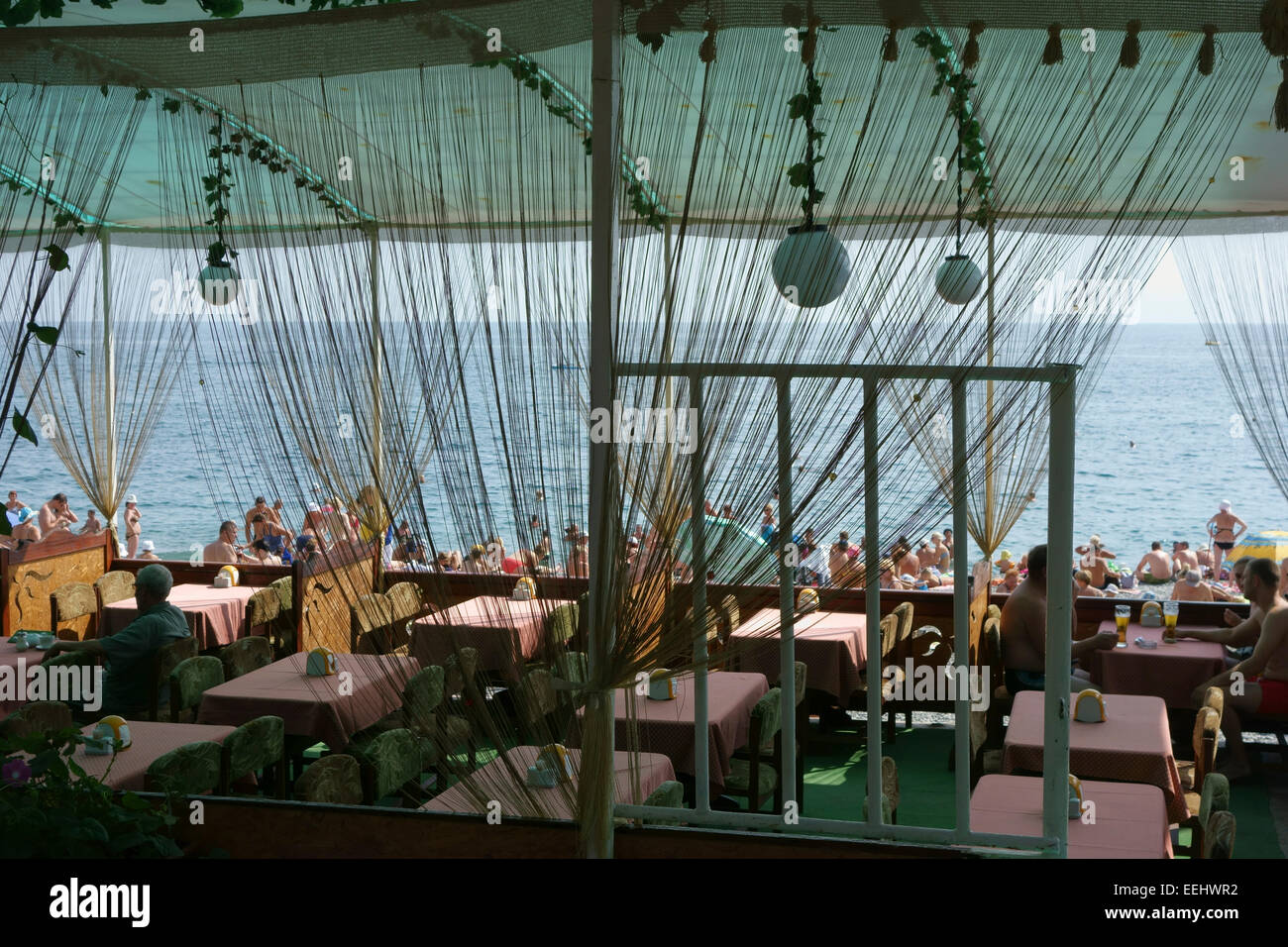 Seaside restaurant and crowded beach in the resort town of Alushta ...