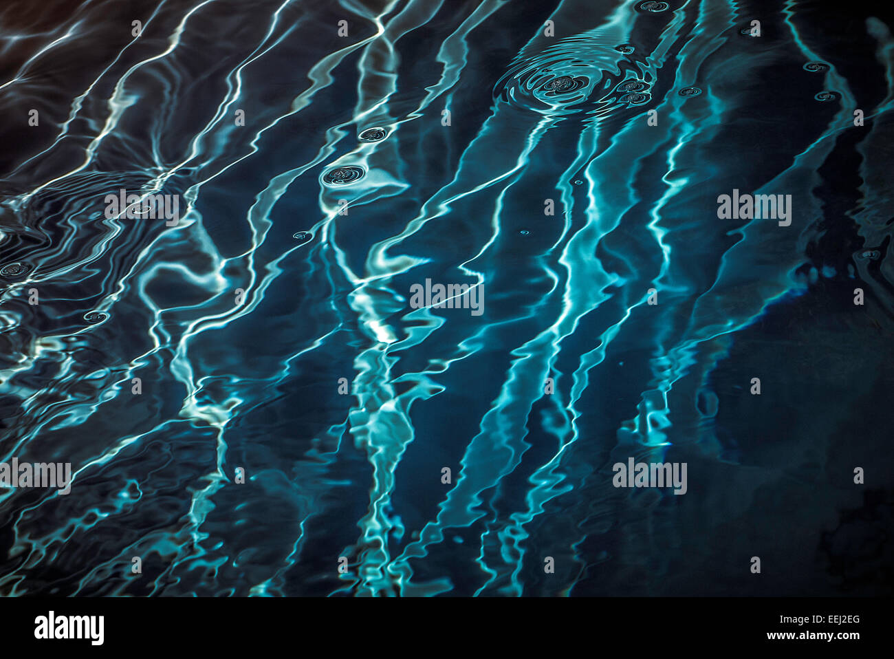 Abstract light patterns at the bottom of a blue swimming pool in Umbria ...