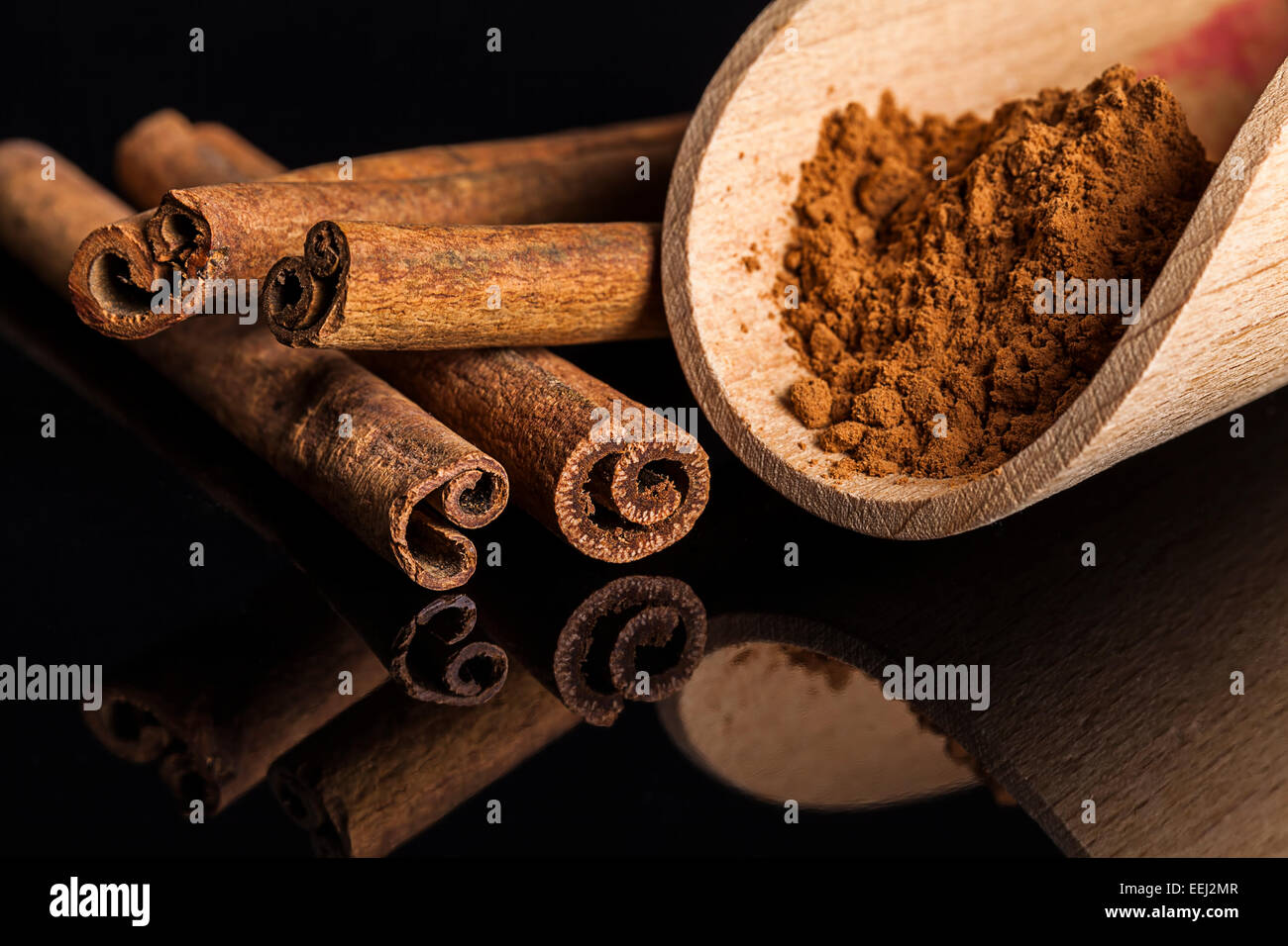 Cinnamon sticks and wooden spoon on dark reflective background Stock ...