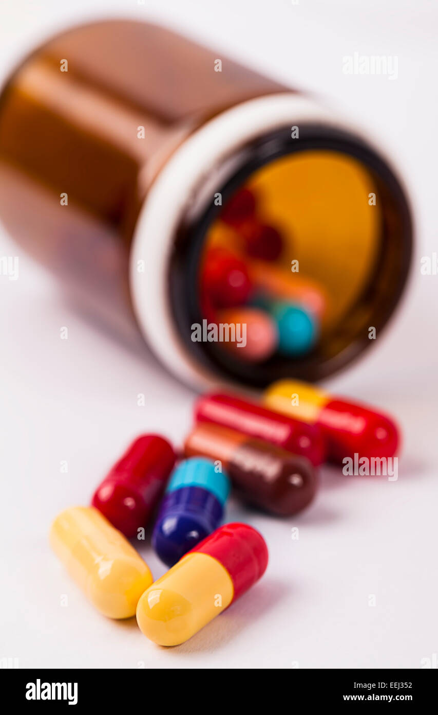 Pills spilling out of prescription bottle Stock Photo - Alamy