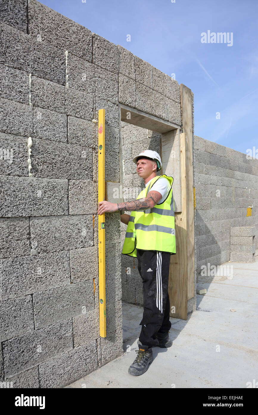 A workman uses a level to check the straightness of Durisol cement ...