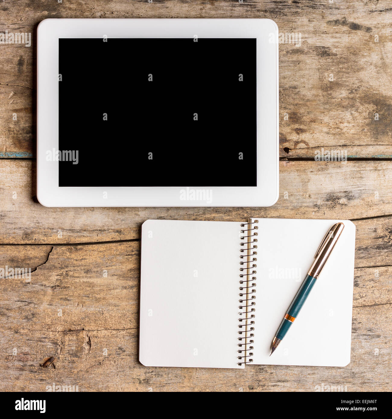 Digital pad with empty black screen and opened notebook with old ...