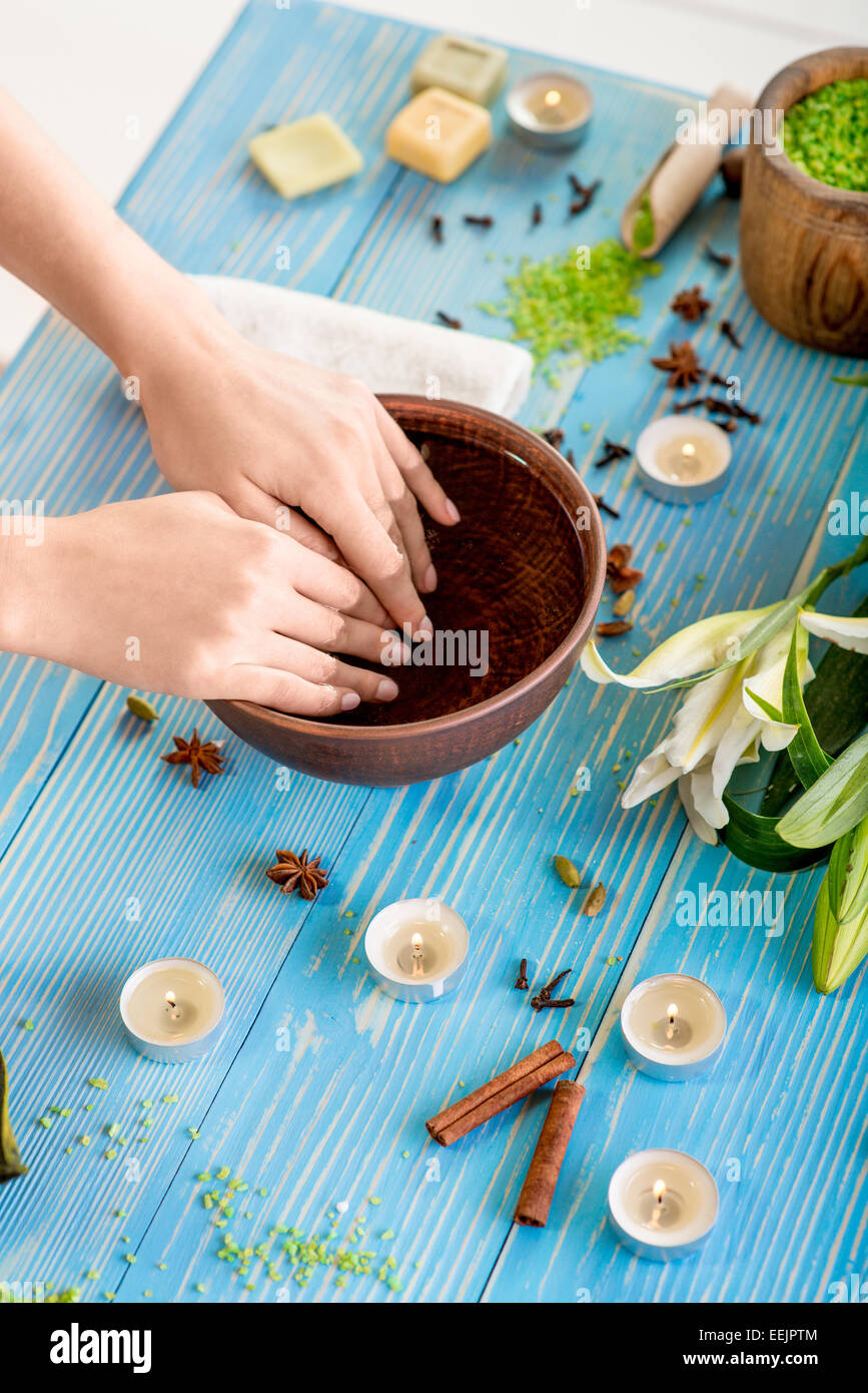 Soaking finger nails in the bath with water on wooden table with spa ...