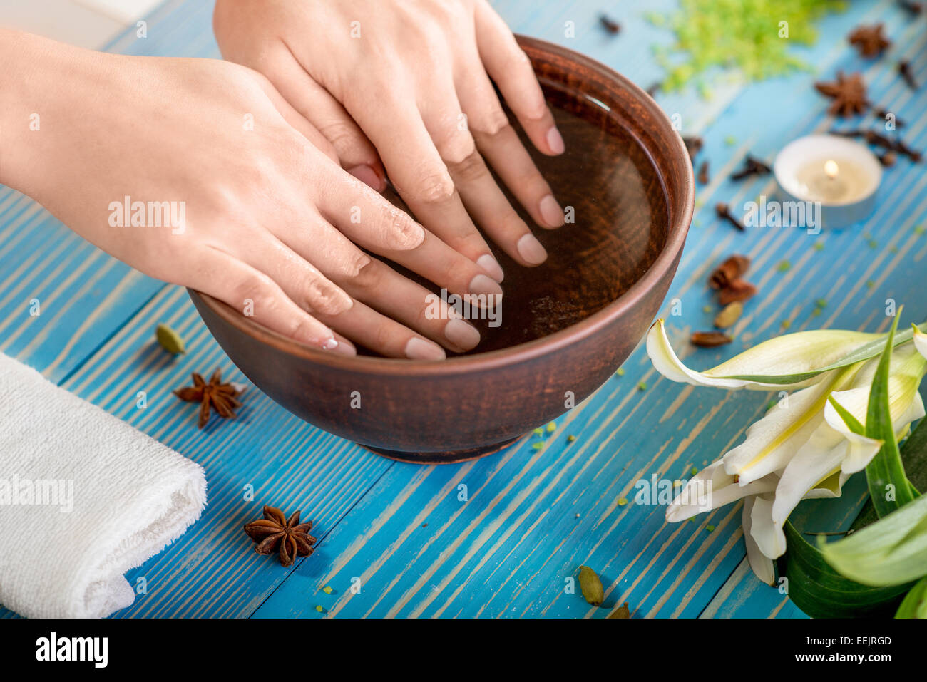 Soaking finger nails in the bath with water on wooden table with spa ...