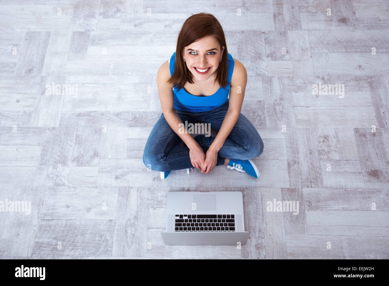 Top view portrait of a happy woman sitting at the floor with laptop ...
