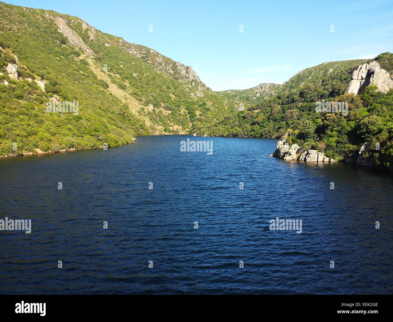expanse of water between the green mountains and dam Stock Photo - Alamy