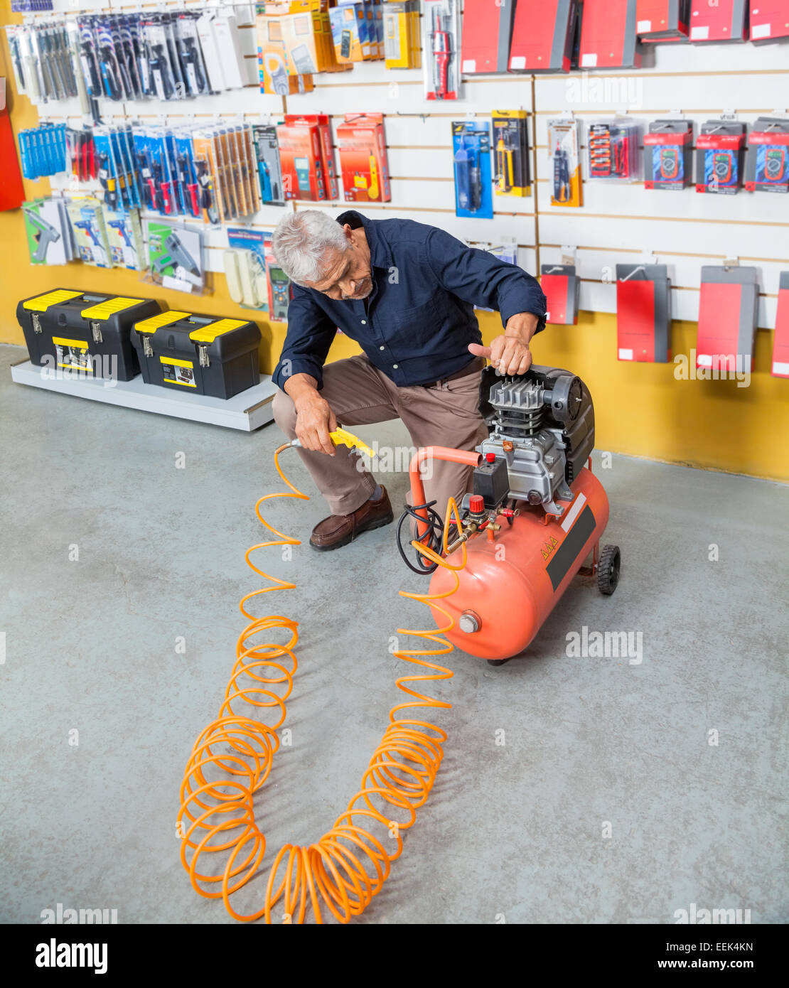 Senior Man Examining Air Compressor In Shop Stock Photo - Alamy