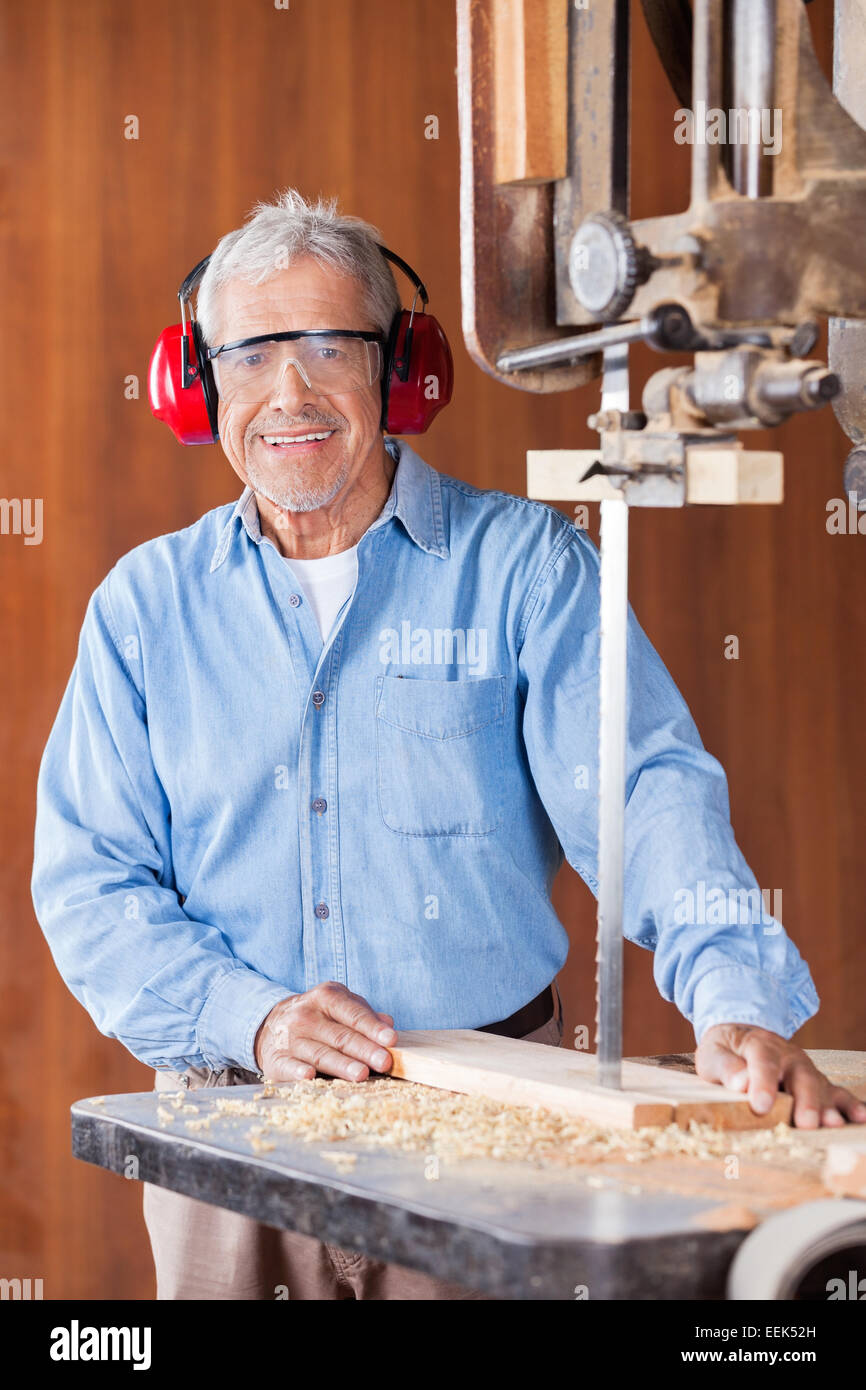 Happy Carpenter Cutting Wood With Bandsaw Stock Photo - Alamy